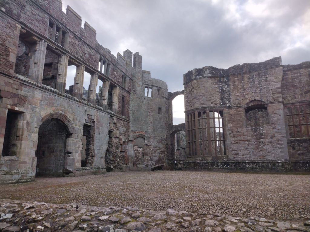 Le côté ouest de la cour en pierre inclinée, avec le hall et son oriel ...